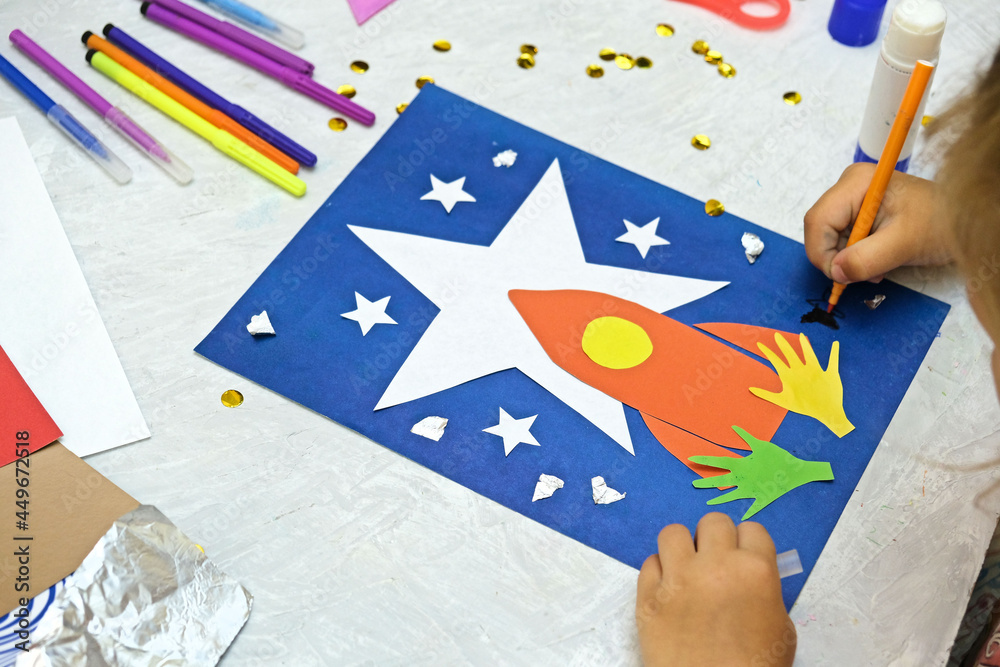 Child making rocket and stars from paper. Creative children play with ...