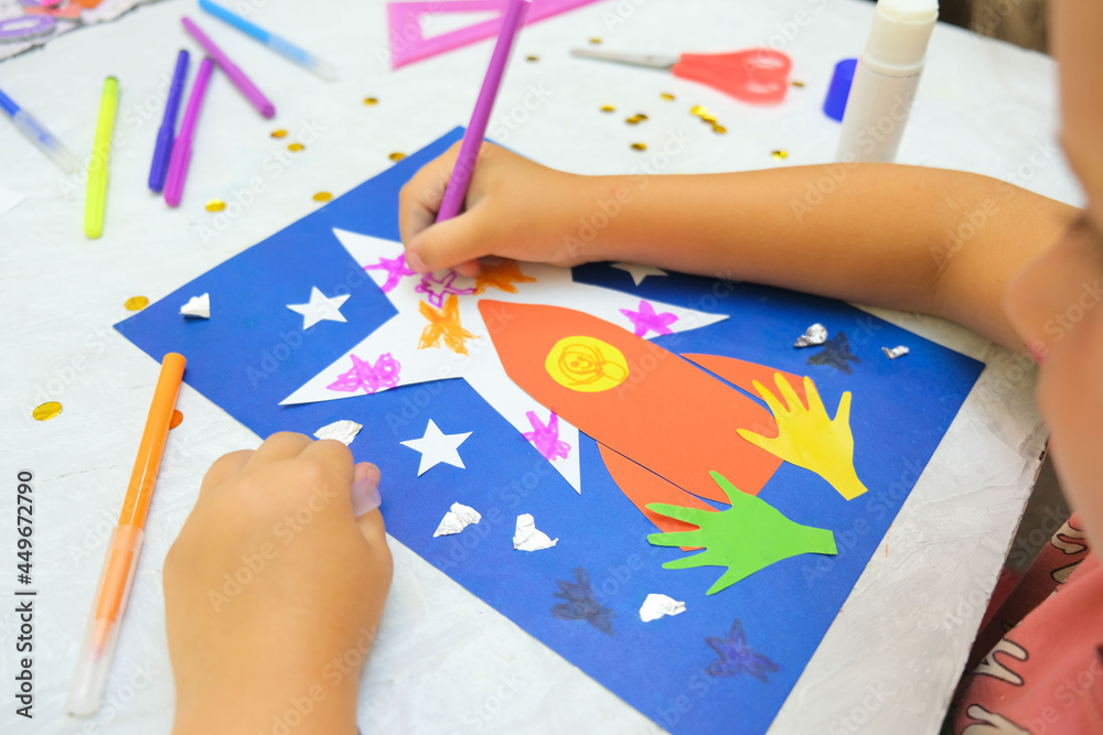Child making rocket and stars from paper. Creative children play with ...