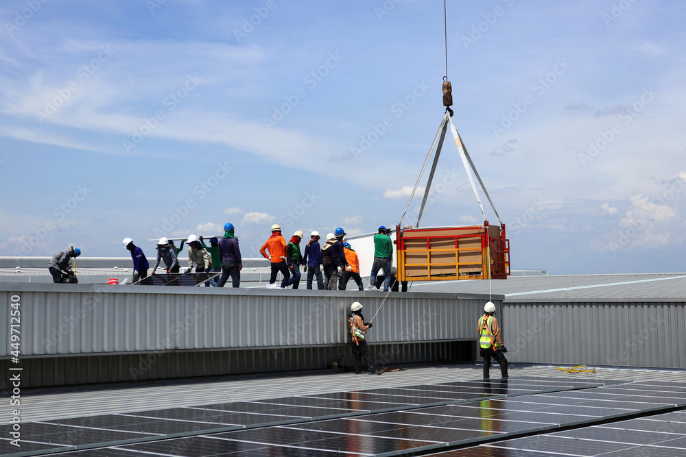 Crane Uploading Solar PV panels on Roof with Installation Workers Stock ...