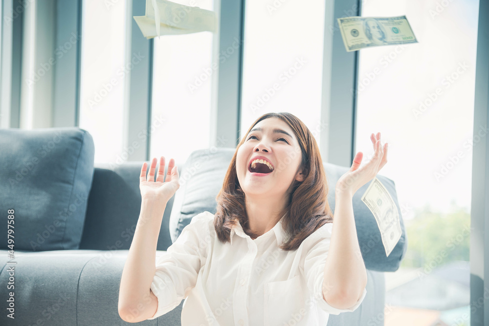 Happy young asian woman holding dollar money and throw in the air ...