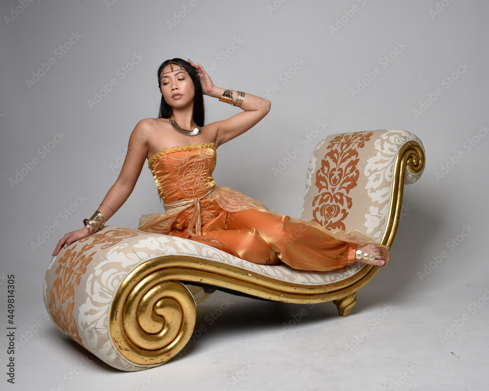 Full length portrait of pretty young asian woman wearing golden Arabian ...
