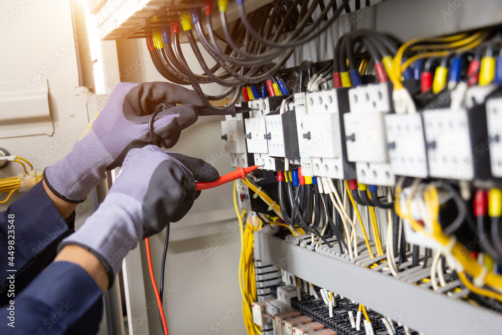 Electrician engineer tests electrical installations and wires on relay ...
