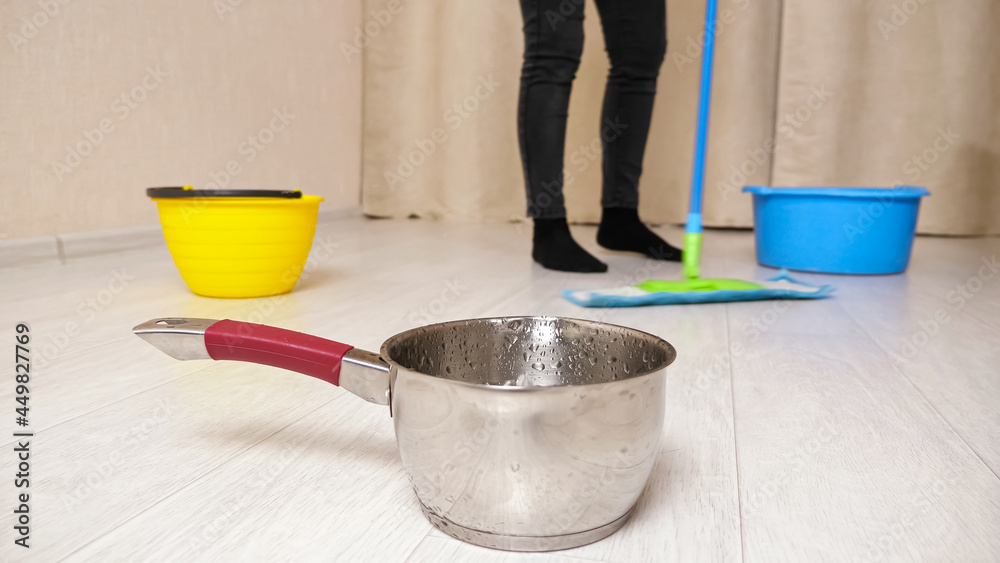 Water comes down into metal saucepot from ceiling after rain while ...