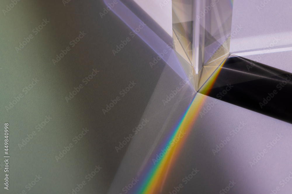Transparent prism dispersing sunlight splitting into a spectrum on a ...