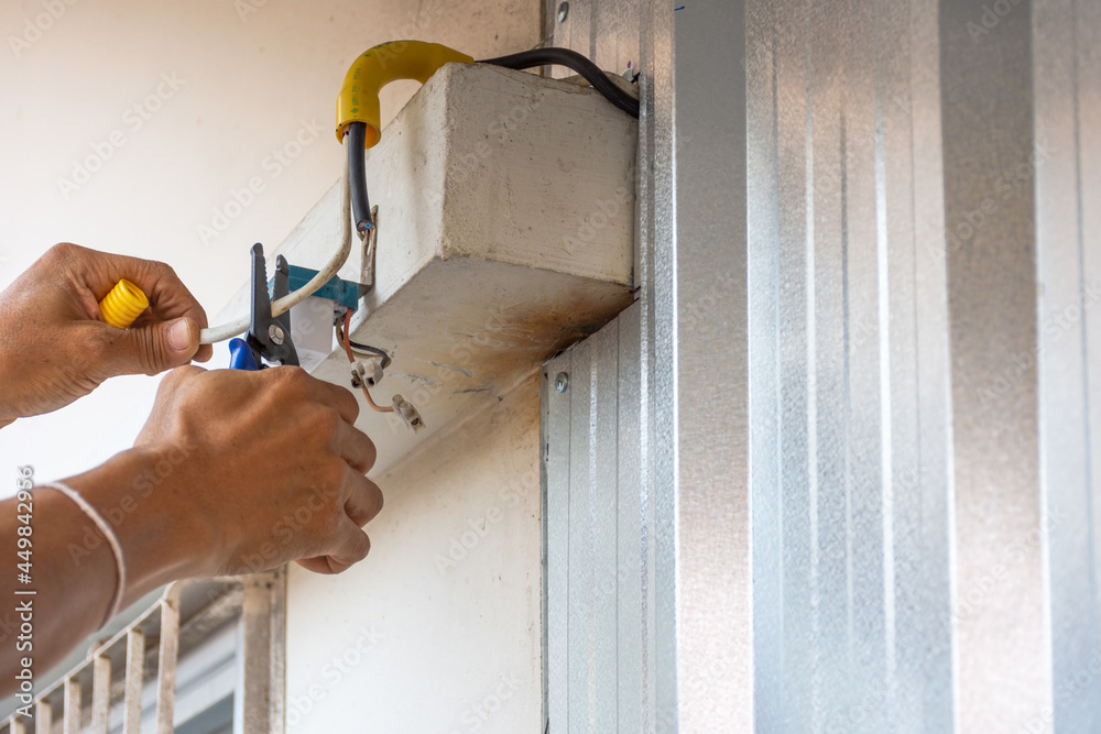 Man hand using the scissors to cut the cable while installing the auto ...