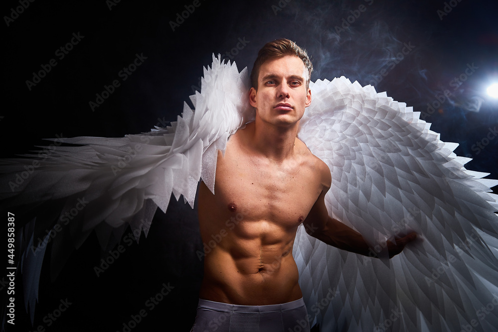 Handsome young athletic man with a bare torso who looks like an angel ...