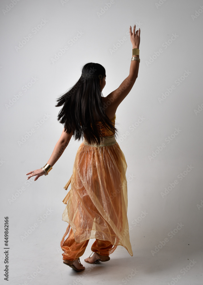 Full length portrait of pretty young asian woman wearing golden Arabian ...