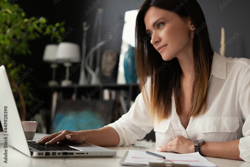 Beautiful Female Data Analyst sitting at the Table Works on a Laptop ...