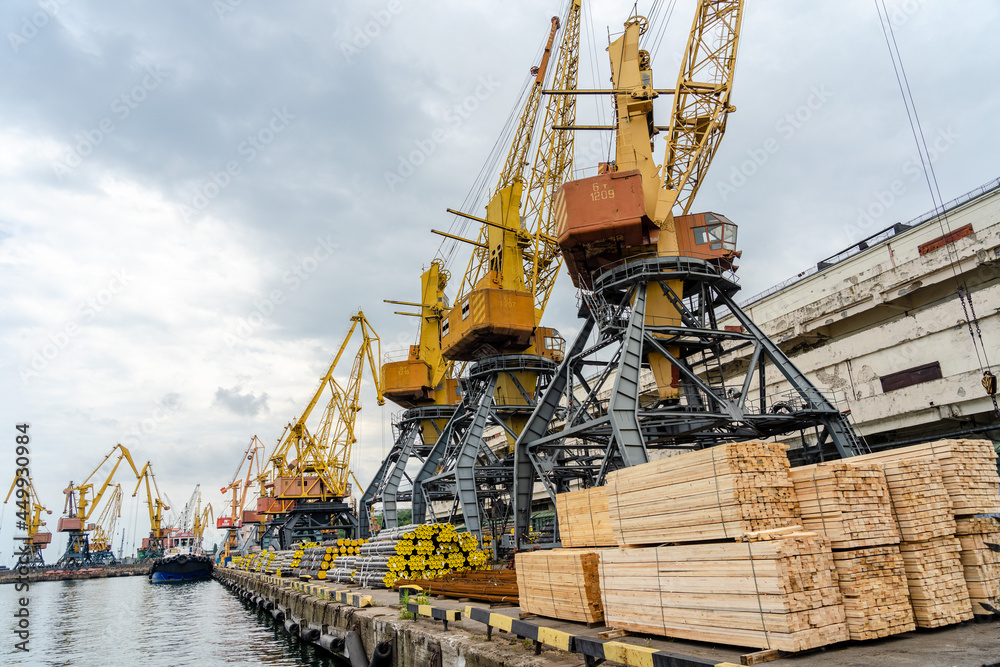 Metal pipes and stacks of timber ready for shipment in sea port in ...