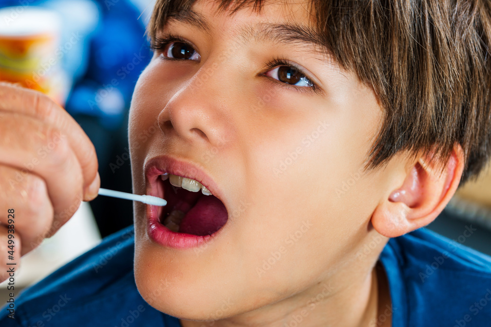 Covid-19 test in elementary age child. A hand holding a cotton oral ...