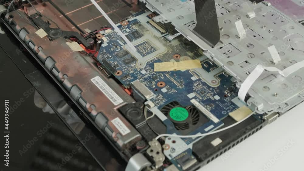 The master cleans the parts of the laptop with compressed air. Laptop ...