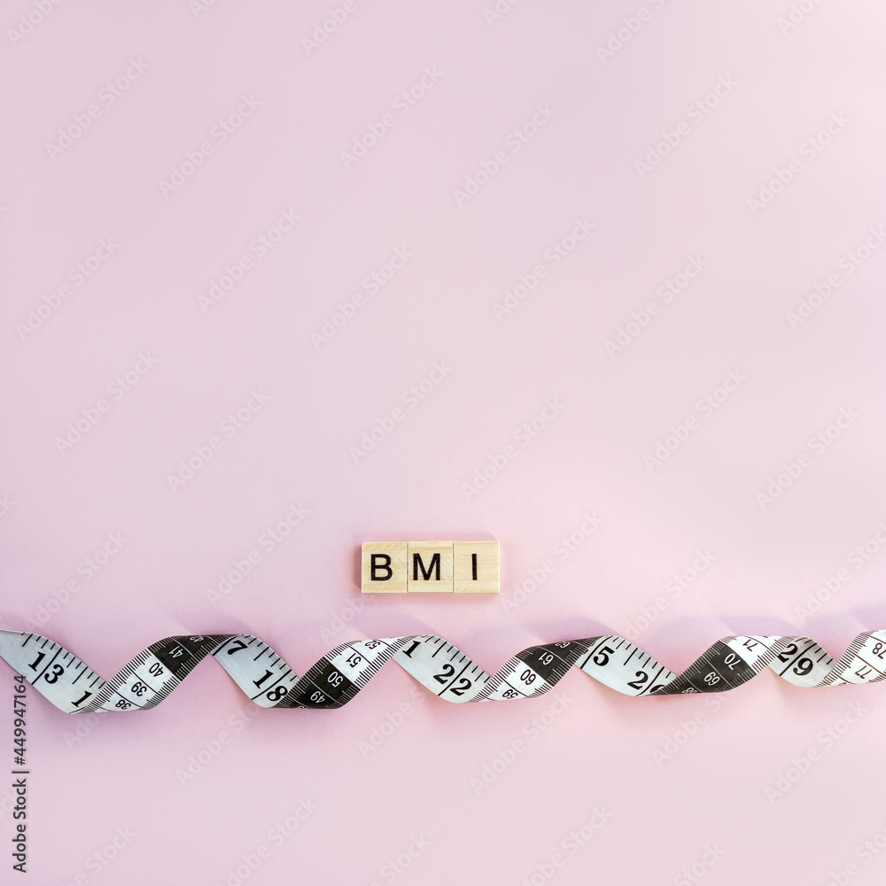 Word BMI on wooden blocks with letters and measuring tape on pastel ...