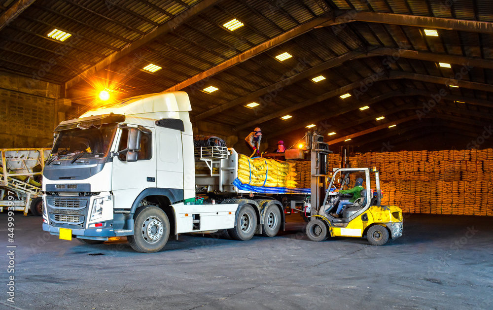 Warehouse intake, forklift unloading bags of sugar cargo from truck to ...