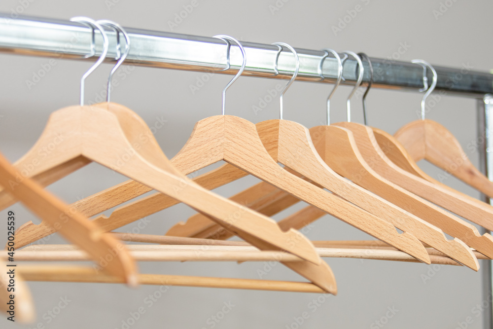 Wooden hangers on a metal bar. Free hangers for clothes in the dressing ...