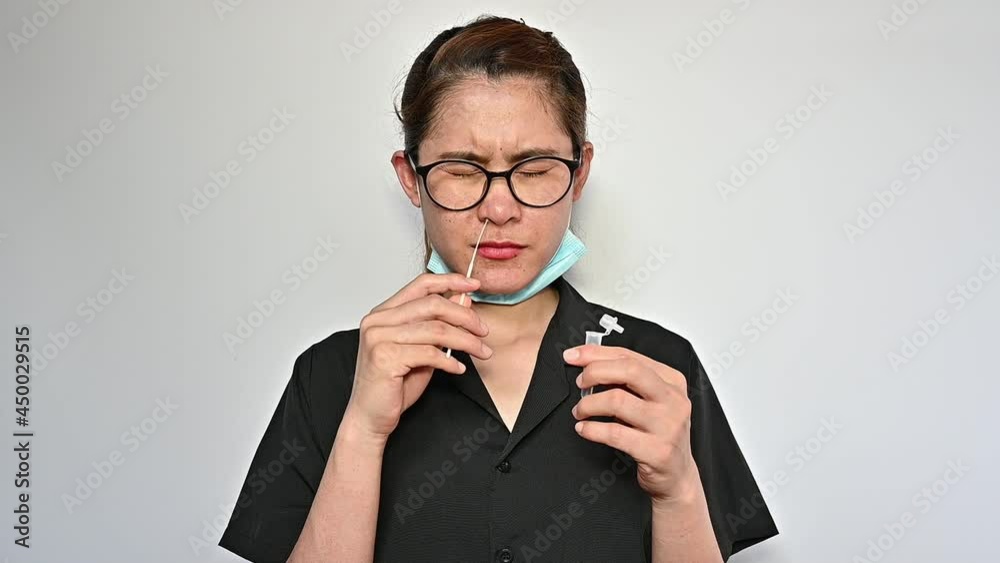 Young Asian woman using rapid antigen test kit by nasal swab herself ...