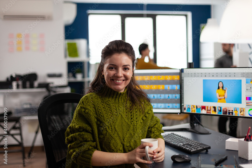 Woman retoucher looking at camera smiling sitting in creative design ...