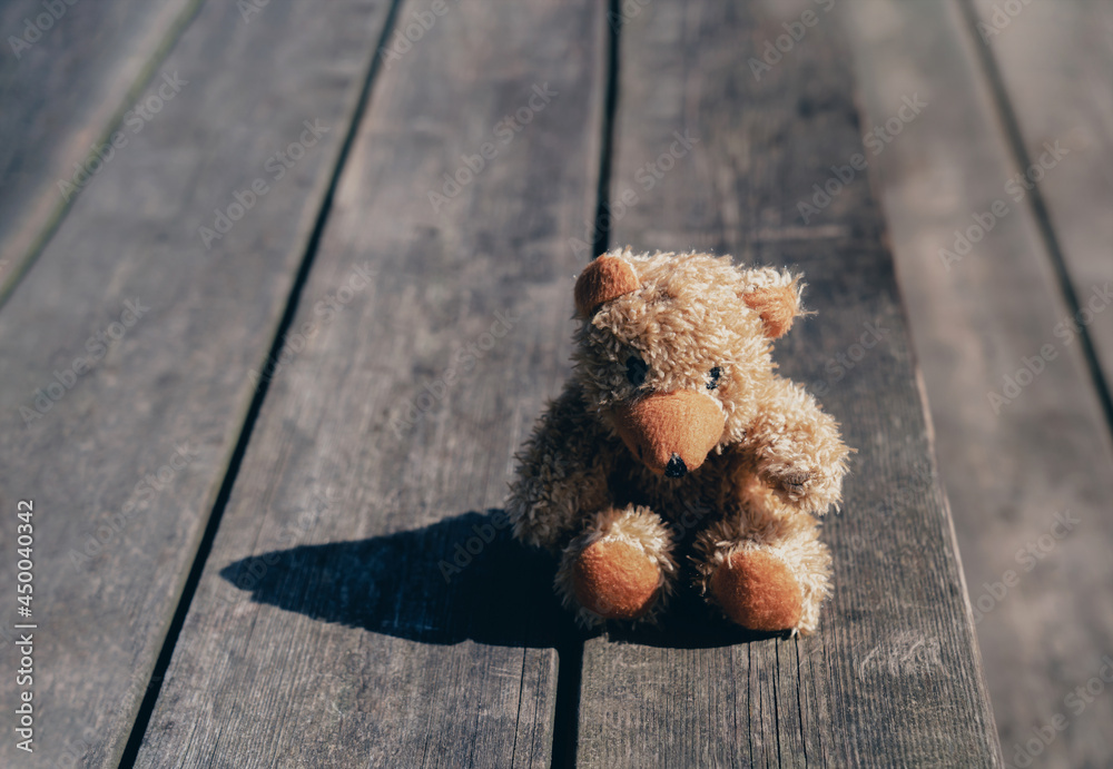 Teddy bear with sad face sitting on wooden table, Loneliness brown bear ...