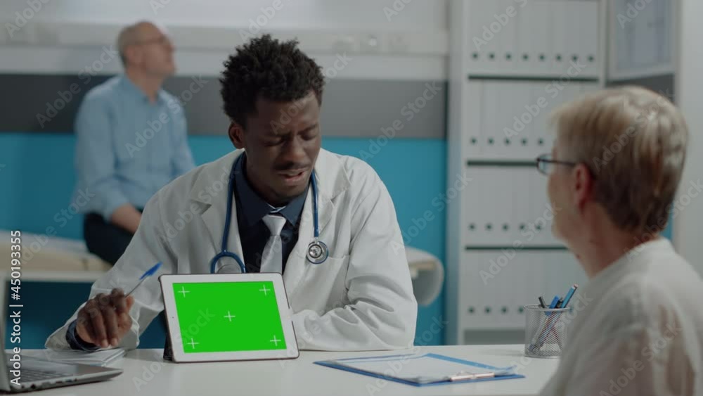 Young doctor with green screen technology on tablet for healthcare ...