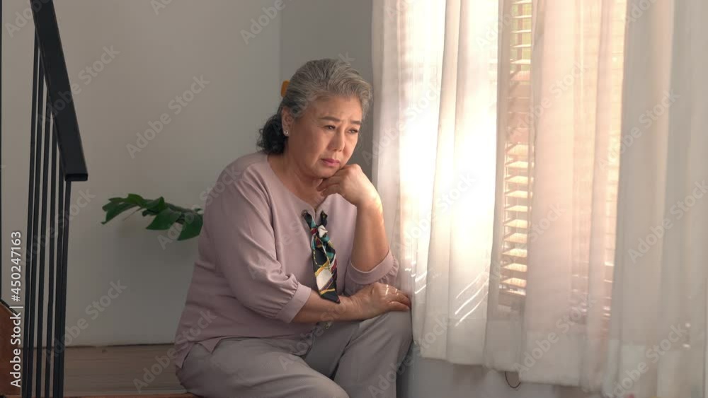 Depressed Asian Senior Woman Sit On Staircase Looking Away By The