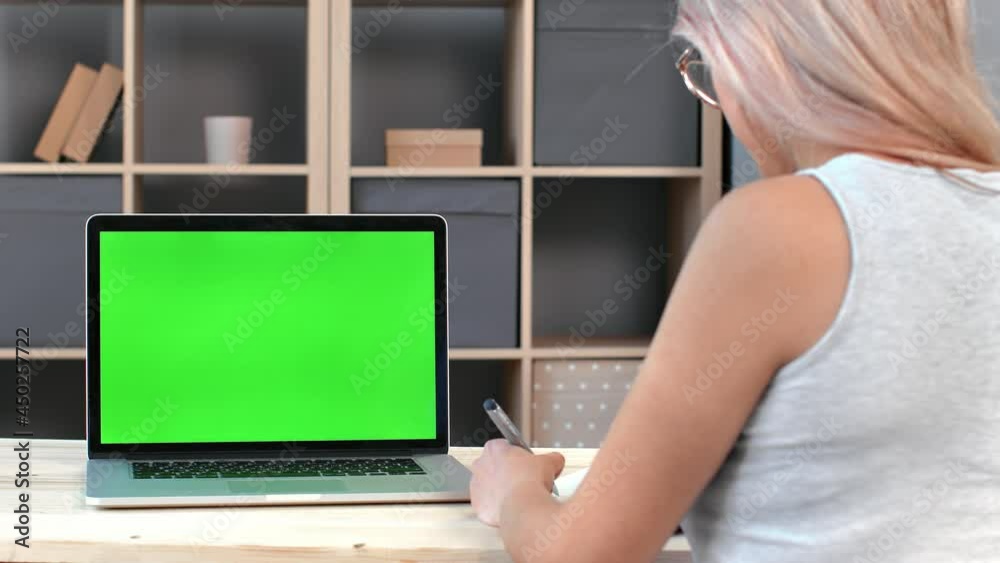 Back view woman student studying e learning taking notes at laptop ...