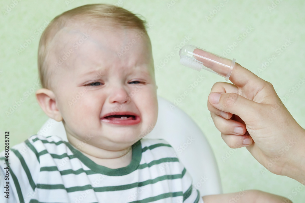 Mom's finger with a brush on the finger with a special attachment. A ...