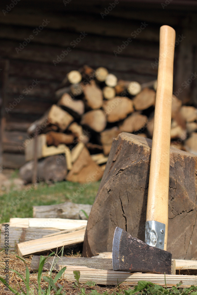 cleaver-ax and firewood by the stump against the background of logs ...