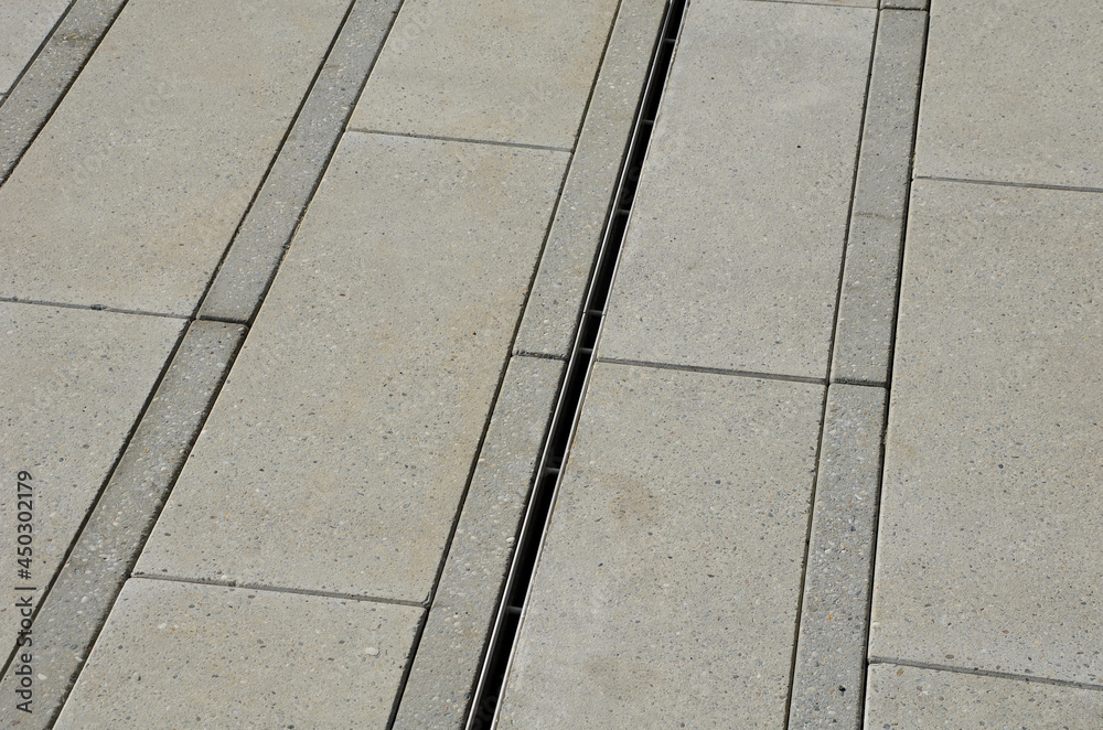 large-format paving made of gray granite. the water is drained in the ...