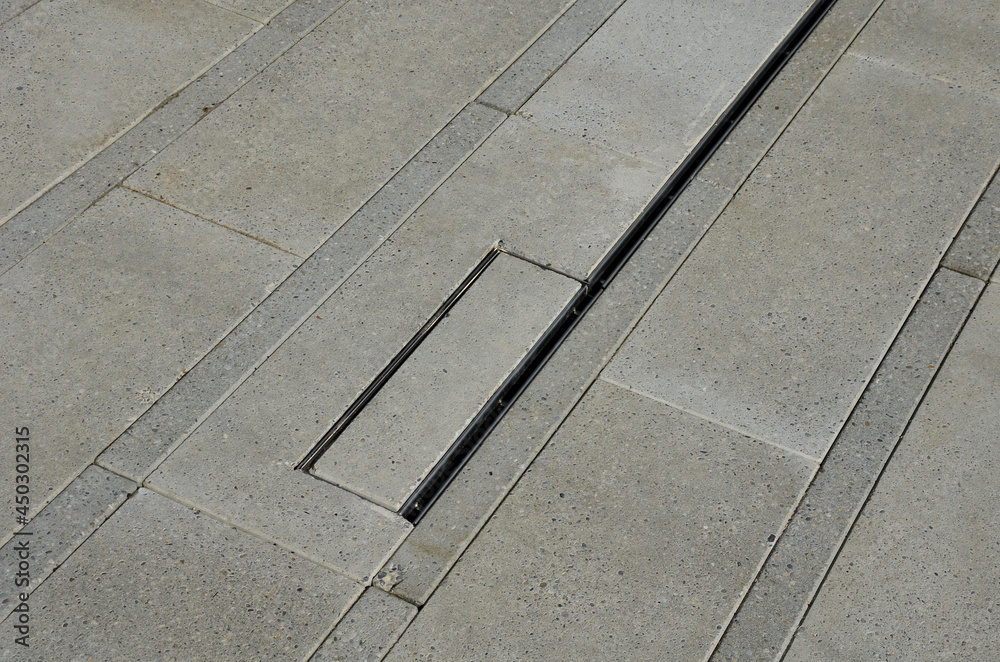 large-format paving made of gray granite. the water is drained in the ...