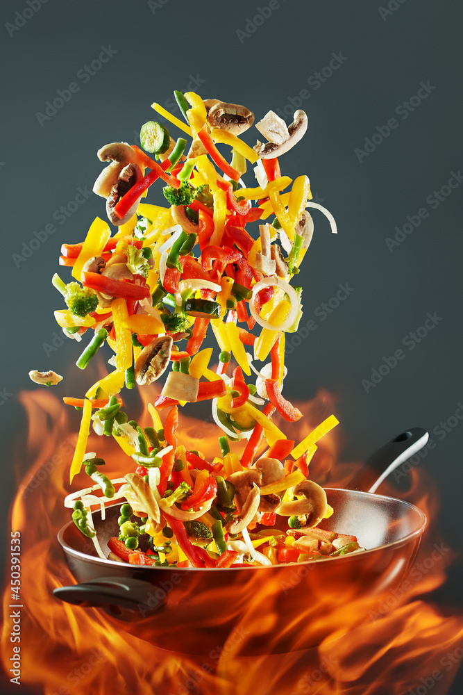 Frying pan wok with vegetables in the air on fire. Vegetables wok ...