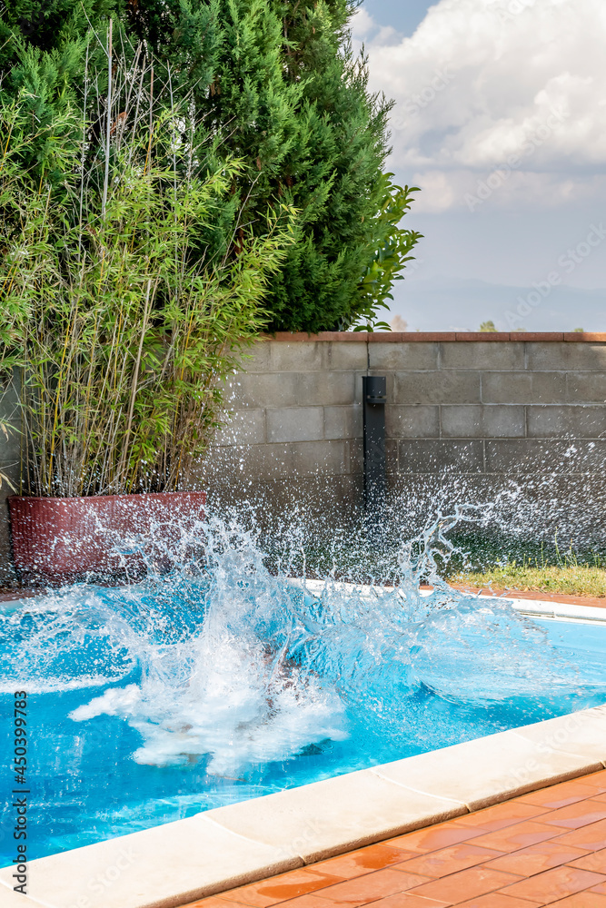 huge splash of water is created by a cannonball dive into a swimming ...