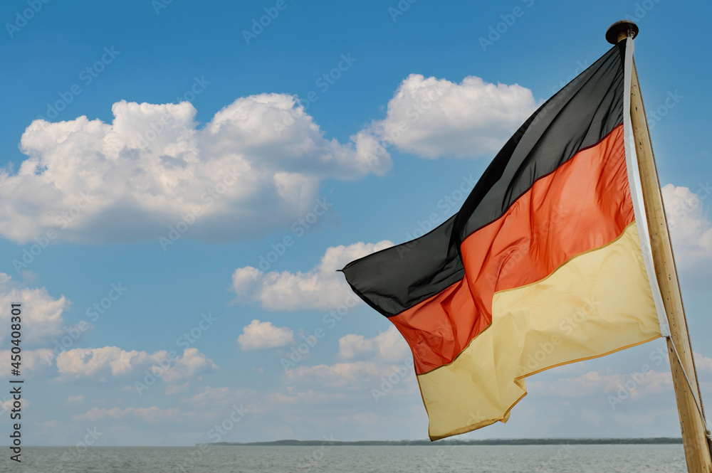 Wehende Deutschland Fahne, Flagge mit Himmel, Wolken und Wasser im ...