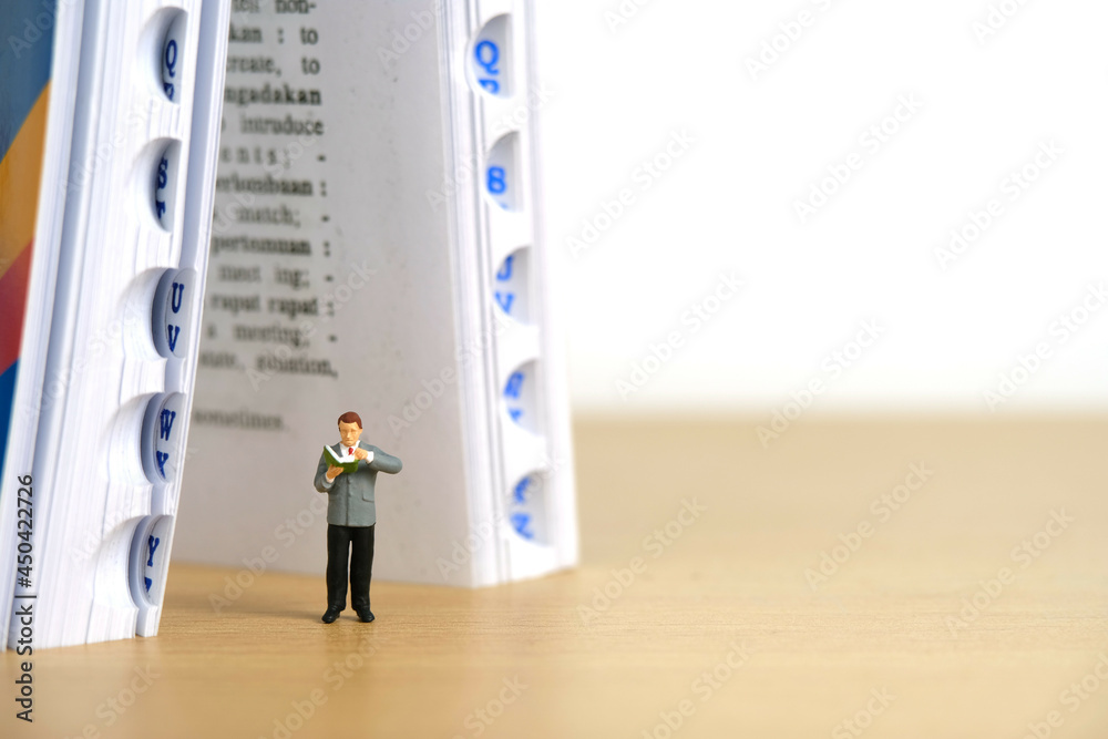 Miniature people toy figure photography. Bookshelf library concept. A ...