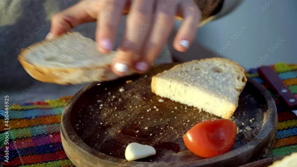 image of a hand cooking a plate of bread with tomato garlic oil salt ...