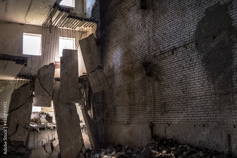 A ruined building with broken ceilings inside with hanging concrete ...