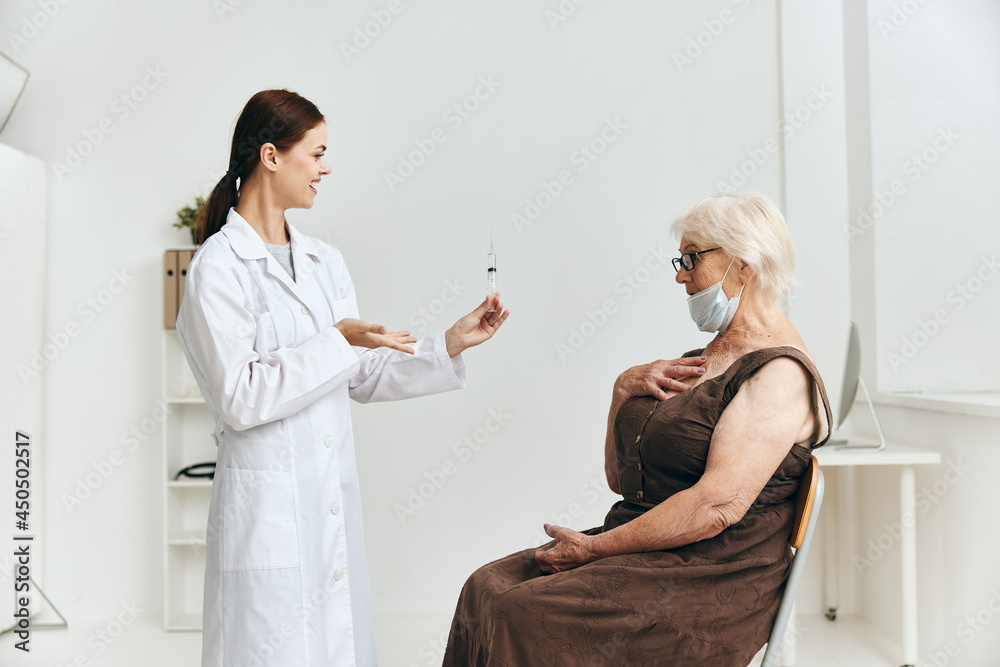 Nurse giving an injection to an elderly woman in the arm fun Stock ...