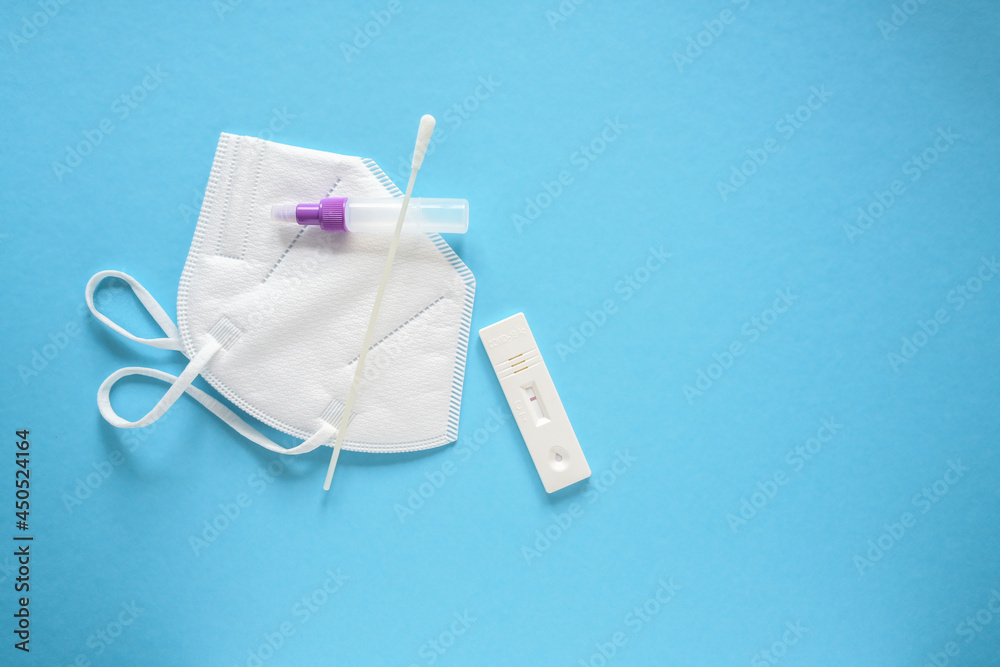 Covid-19 rapid test, utensils and a medical ffp2 face mask on a light ...