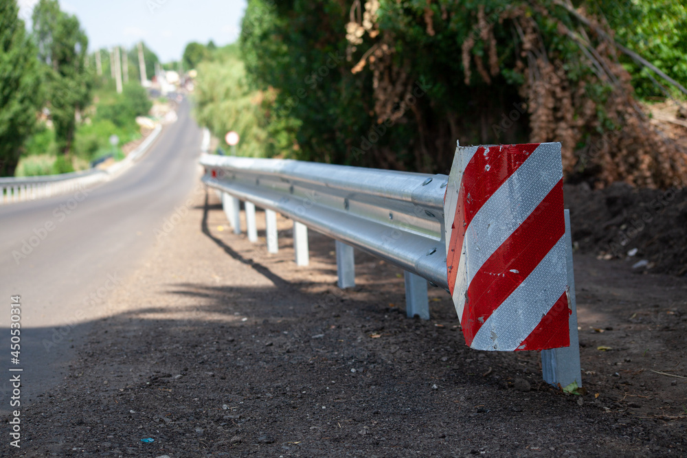 red road reflectors along the road. metal road fencing of barrier type ...