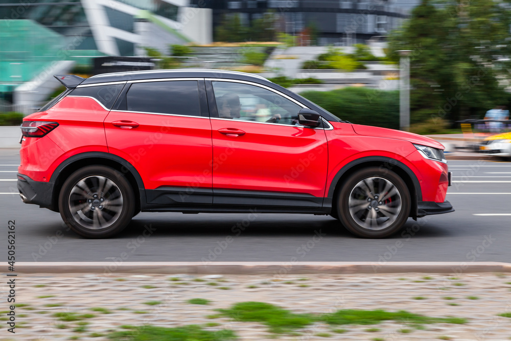 red Geely Binyue car driving in city with motion blur, view from the ...