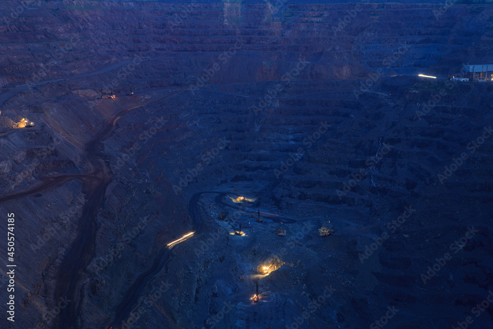 The process of ore extraction in the quarry at night. Heavy industry ...