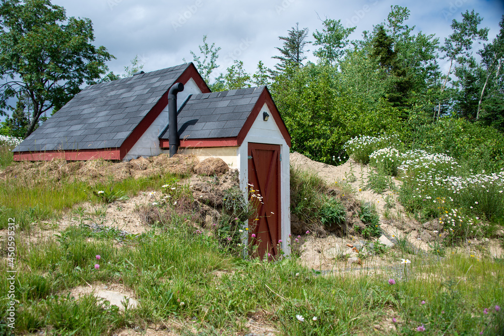 A red and white historic root cellar or cold storage building with a ...