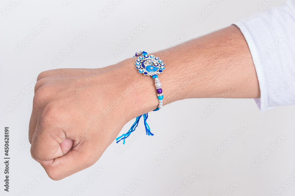 Hand wearing beautiful blue diamond design rakhi on the occasion of ...