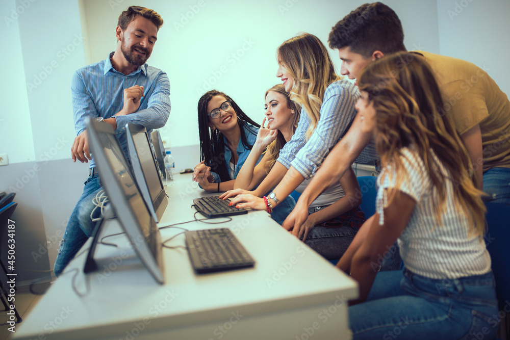 College students sitting in a classroom, using computers during class ...
