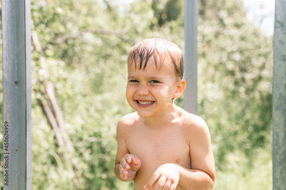 little contented wet four year old kid boy with water drops on his skin ...
