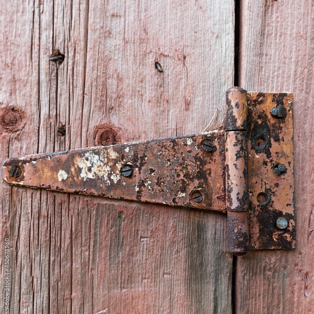 Rusty hinge on red barnwood Stock Photo | Adobe Stock