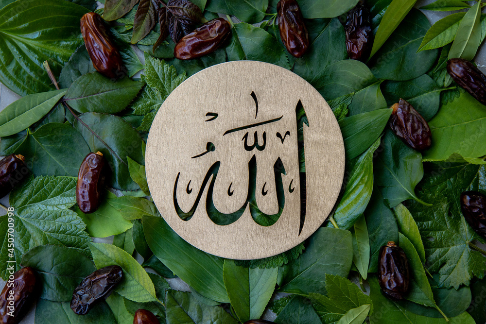 Name of Allah in arabic on gold wood, green leaves and dates fruit ...