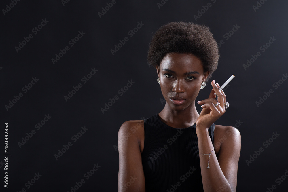 Pretty model african american woman smoking cigarette on black ...