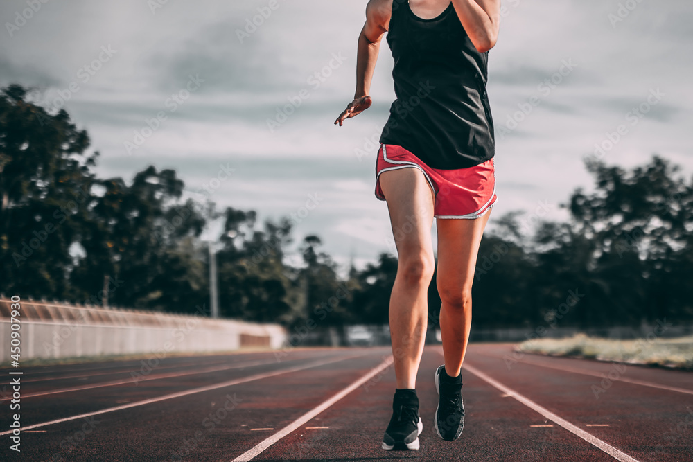 Feet of a female runner who is stepping on the running field with ...