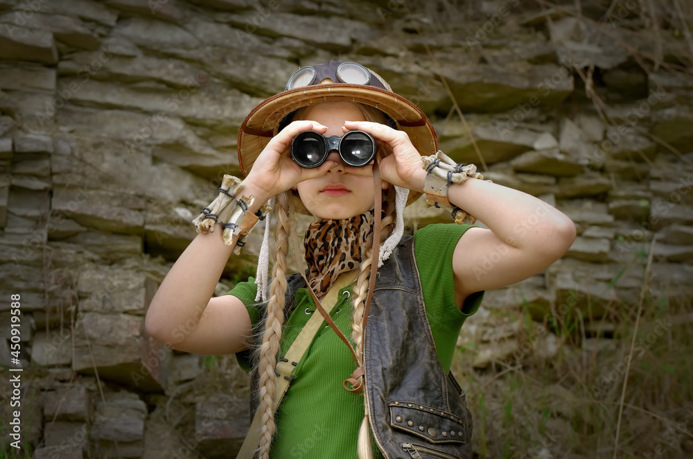 A young girl is dressed up as an explorer. She is seen in front of a ...