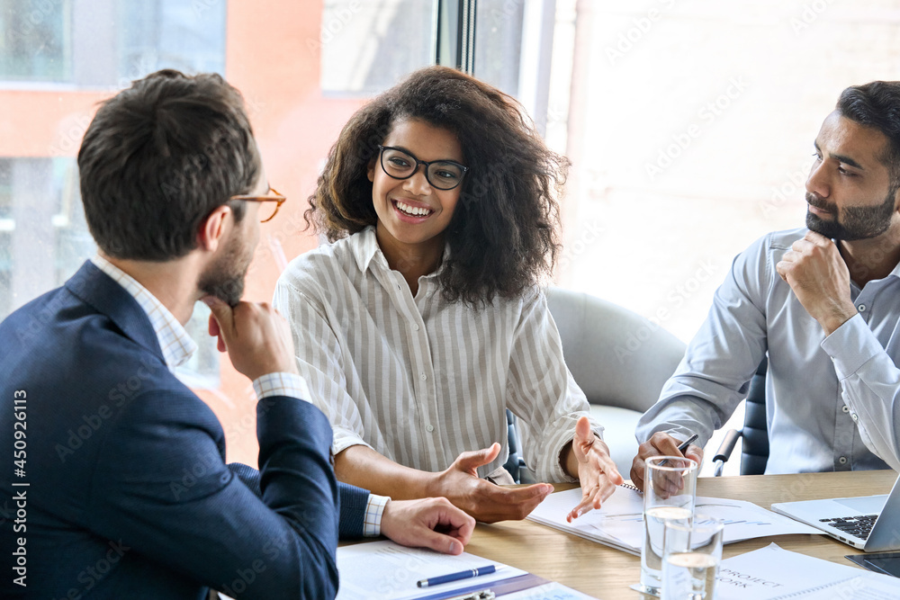 Smiling female manager talking to businessmen team discussing financial ...