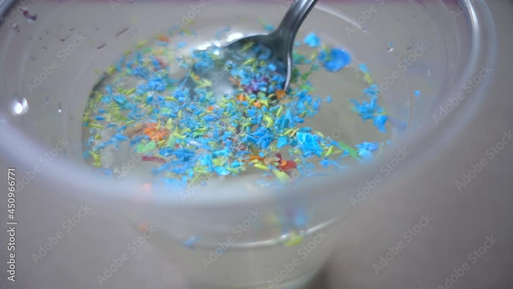 Top view of a single-use plastic cup with microplastics inside. Slow ...